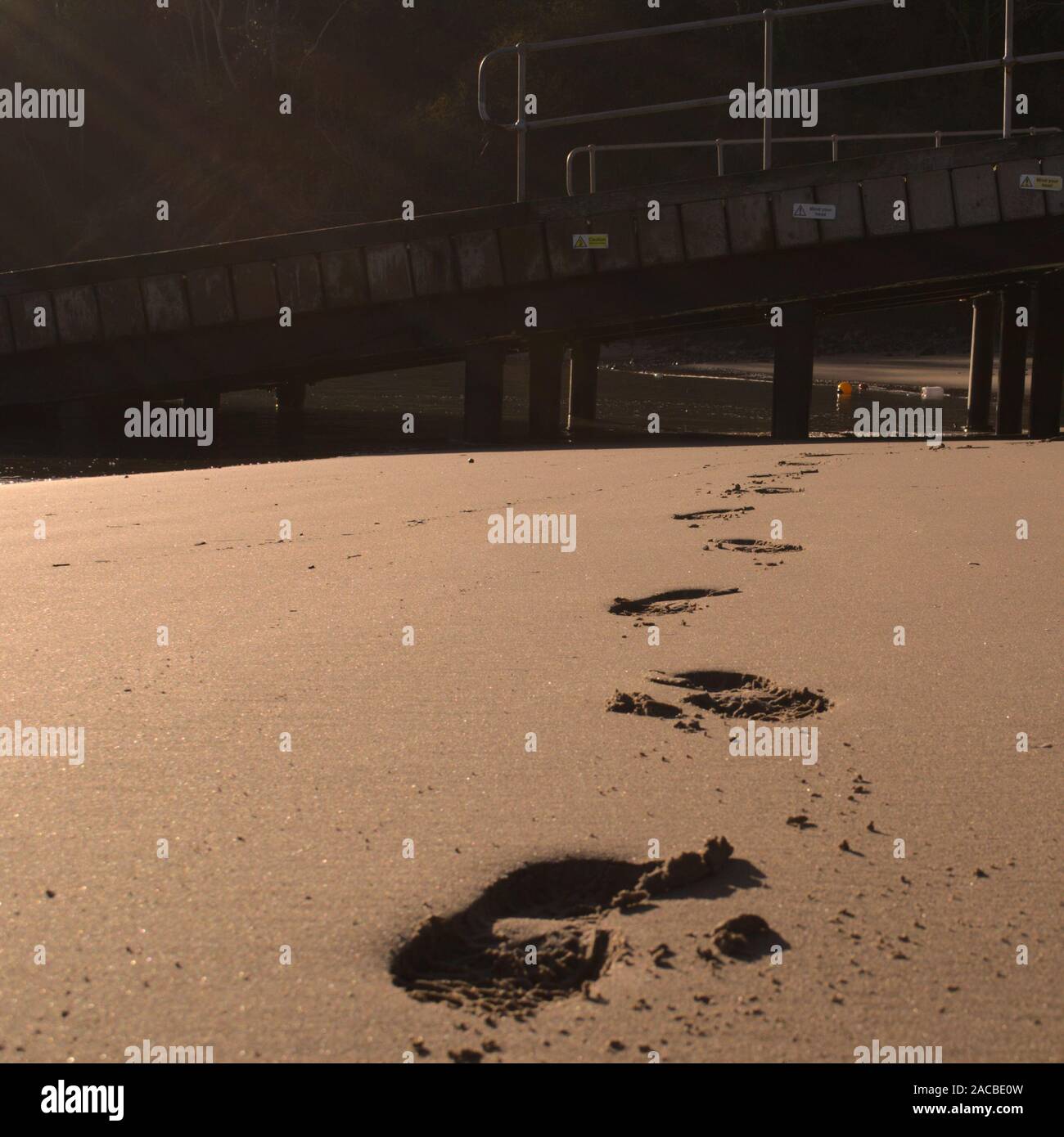 Perspective of footprints on the sandy beach Stock Photo - Alamy