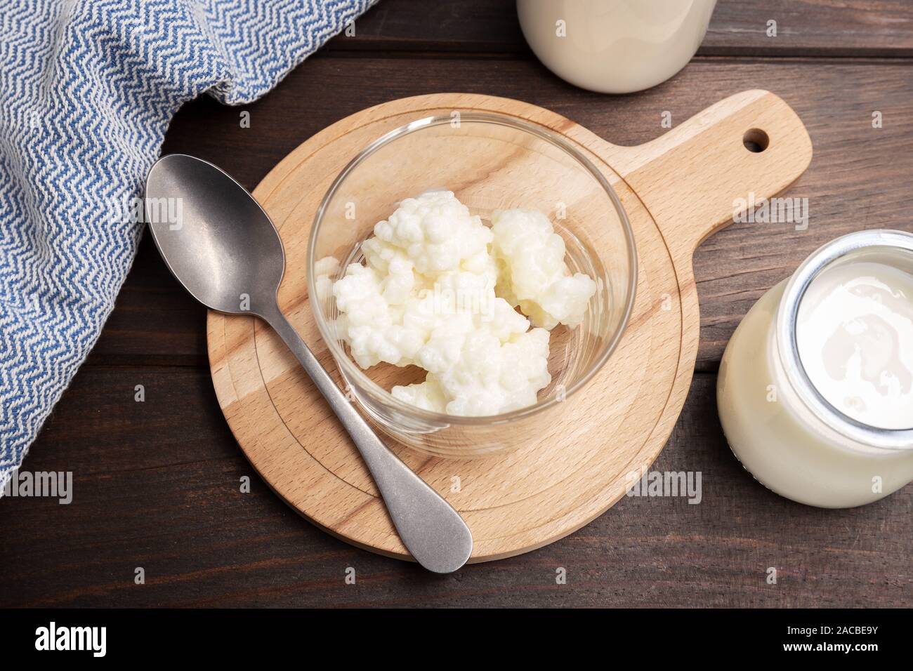 Milk kefir grains in jar on wooden table. Yeast bacterial fermentation ...