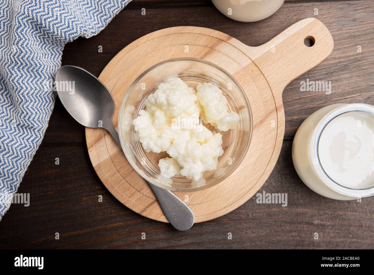 Milk kefir grains in jar on wooden table. Yeast bacterial fermentation ...