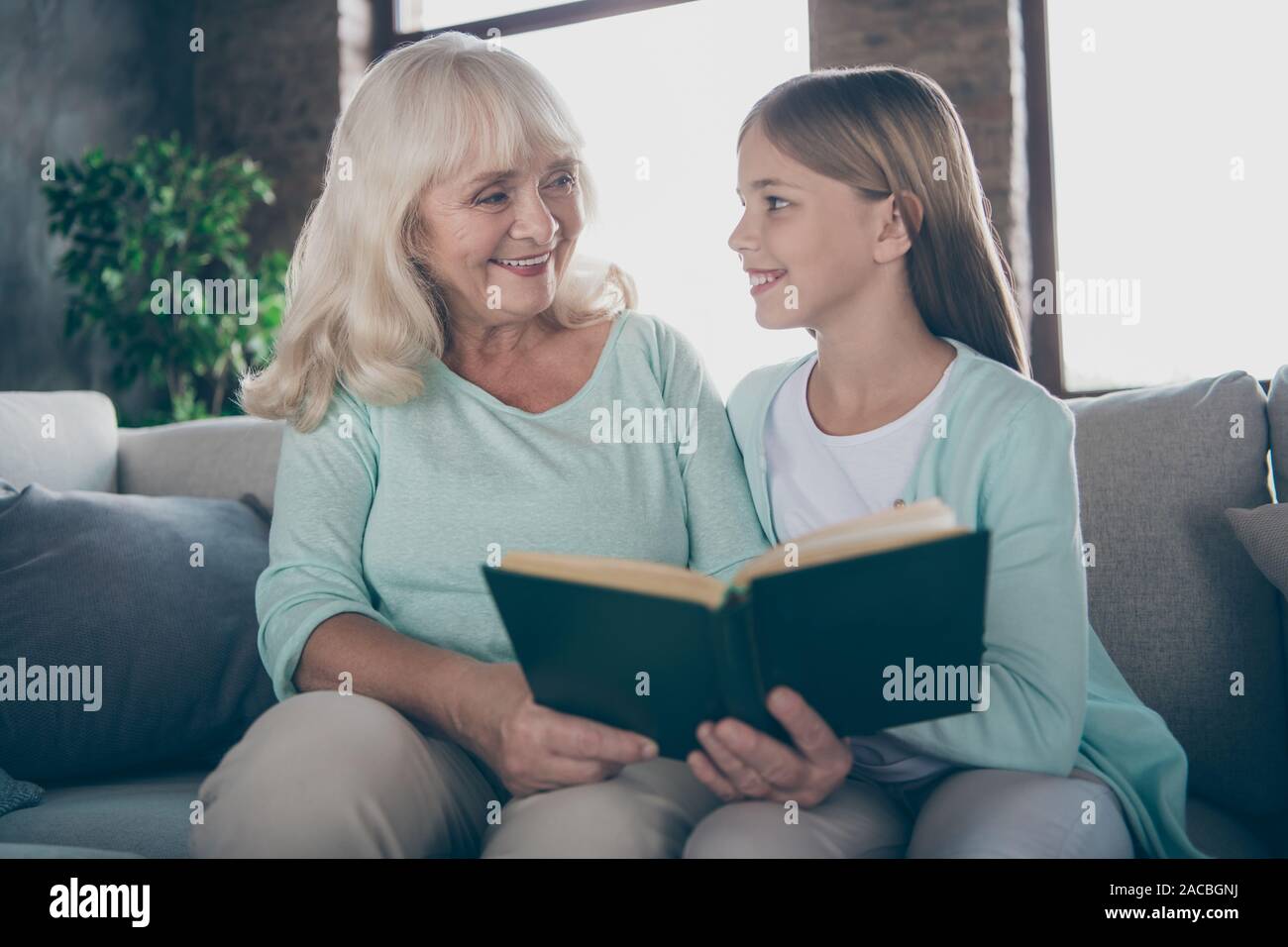 Photo of two people cute aged granny and little granddaughter sitting ...