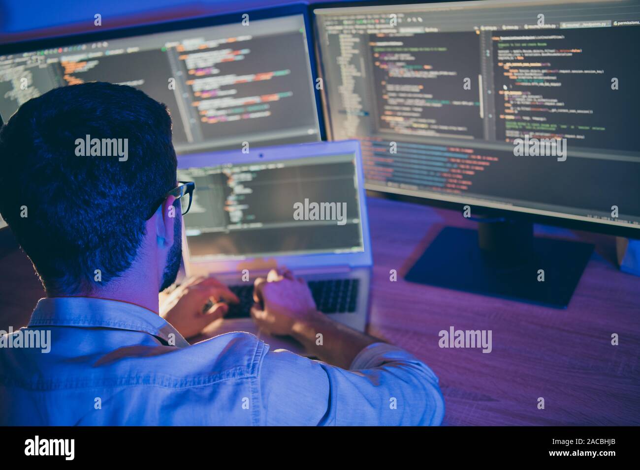 Rear behind view photo of it skilled specialist guy sitting night comfy ...