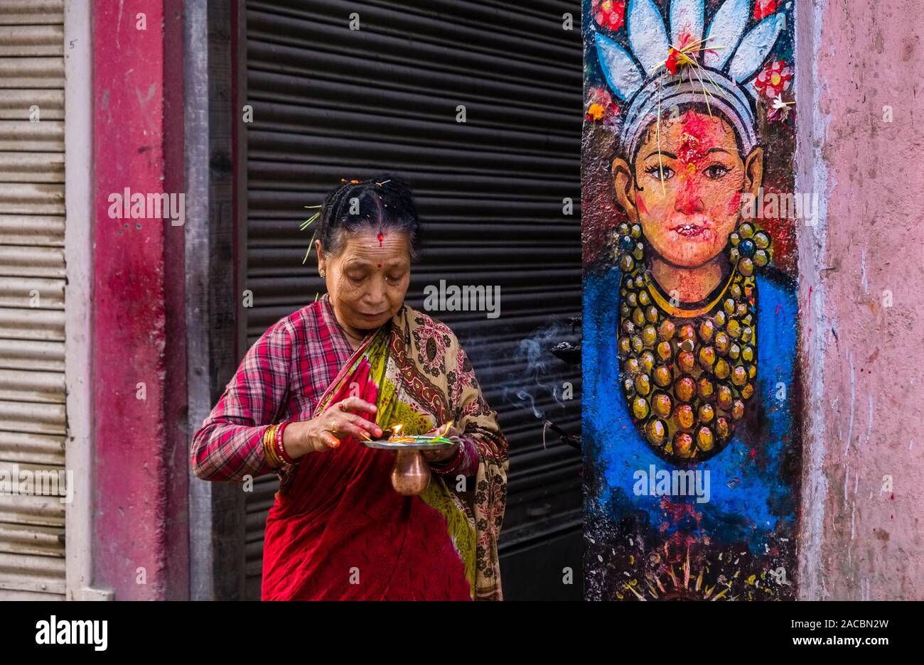 Devotee is offering Prasad, religious food, to the painting of a ...