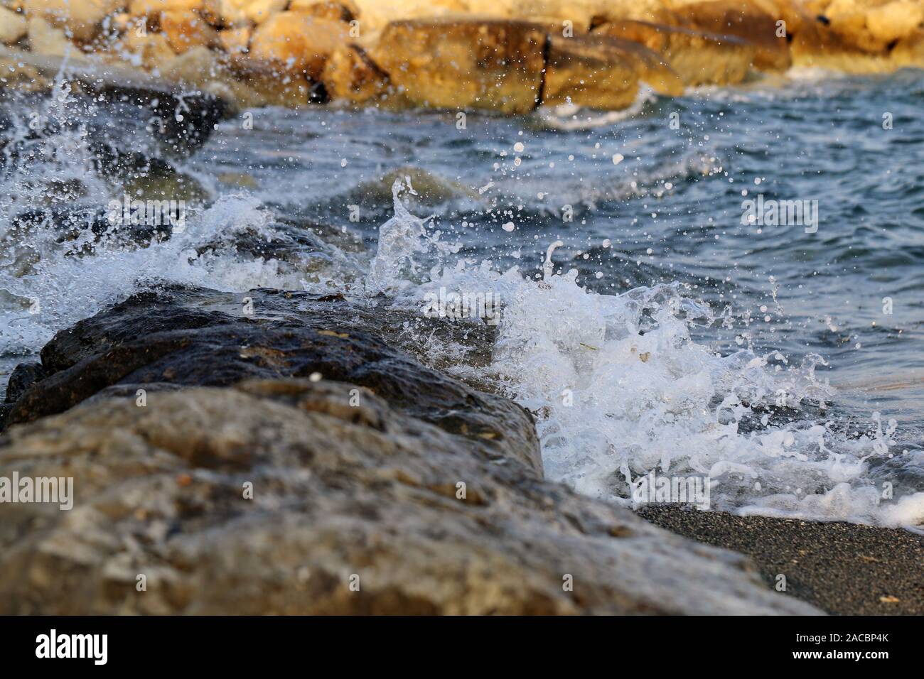 Waves hitting the rocky cliffs in a beach located in Cyprus, Europe ...