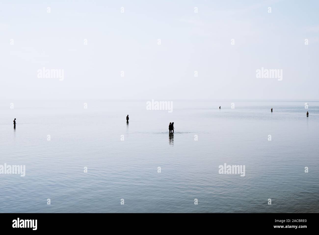 group of people walking and wading through shallow water at German ...