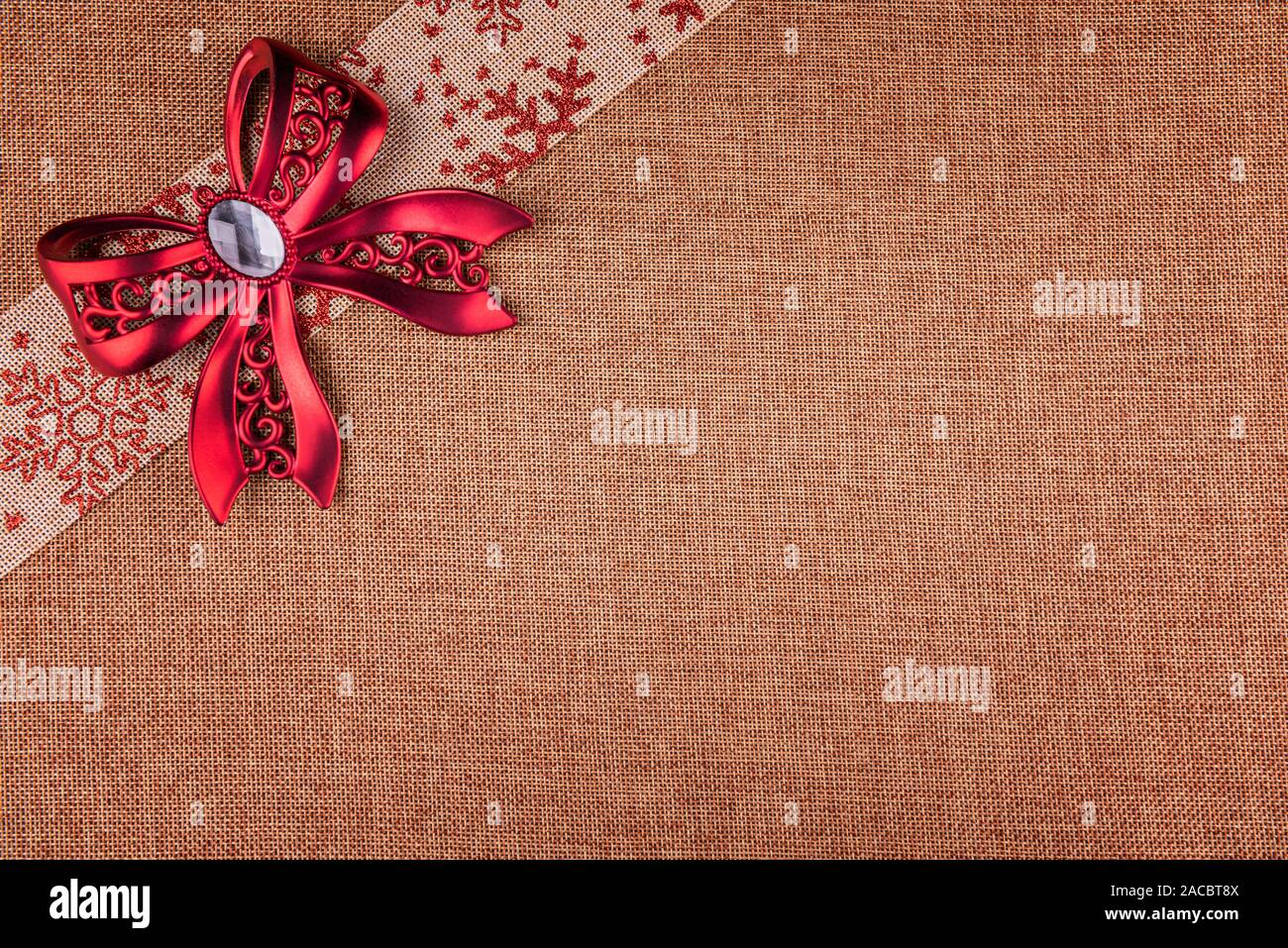 Beautiful shiny red tied metal bow on beige burlap ribbon with red ...