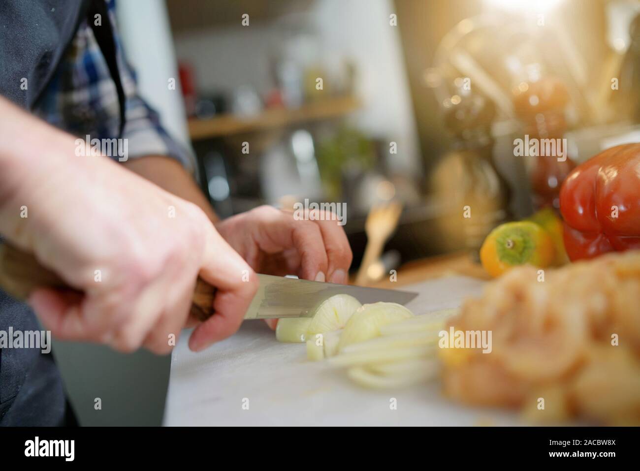 Closeup of mans' hand cutting vegetables in home kitchen Stock Photo ...