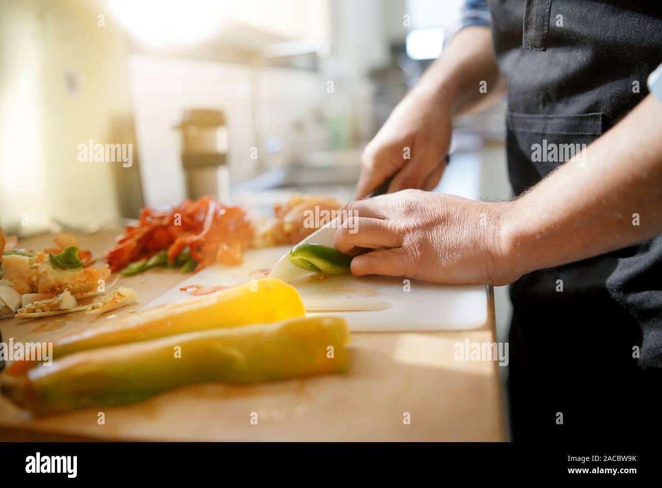 Closeup of mans' hand cutting vegetables in home kitchen Stock Photo ...