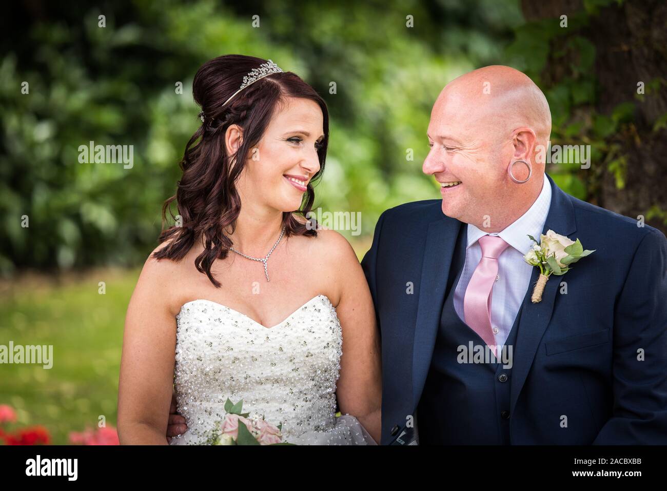A bride and groom smiling, laughing together happy and in love on their ...