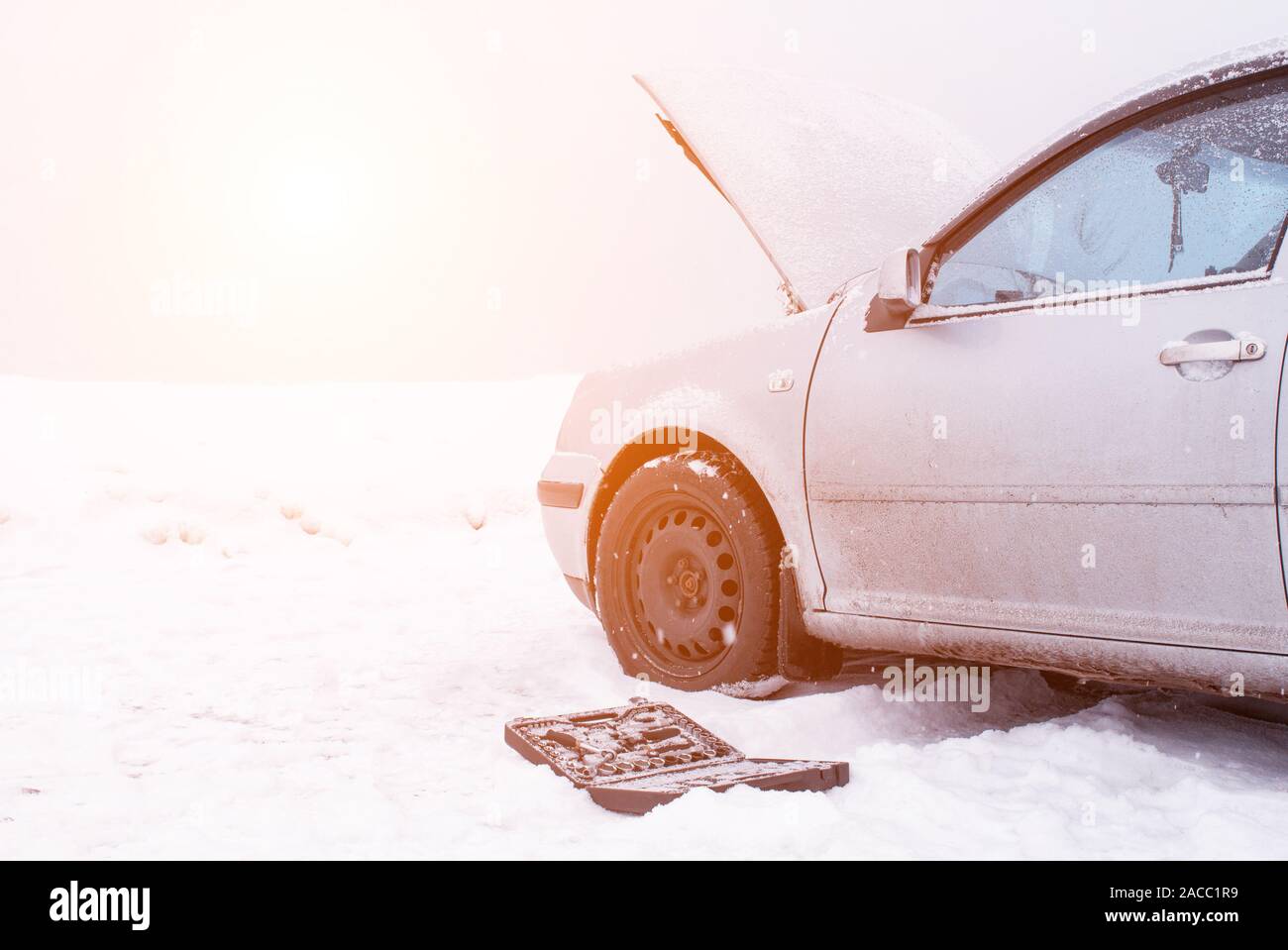 A set of automotive tools next to a car in winter. The concept of low ...