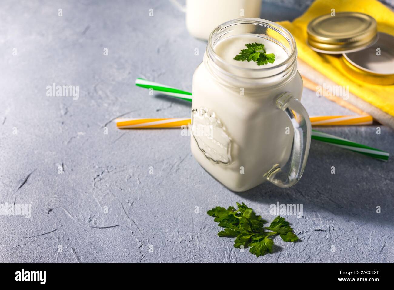 simple homemade kefir in a glass with spices and herbs on a gray ...