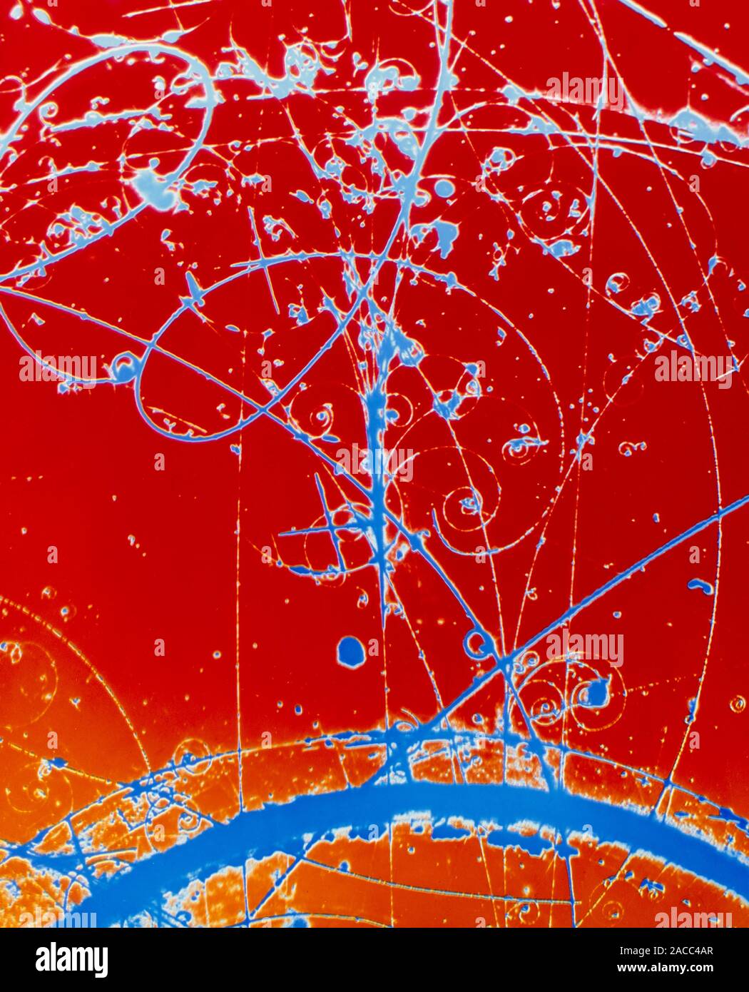 Particle tracks in a bubble chamber. Coloured photograph of a neutrino ...