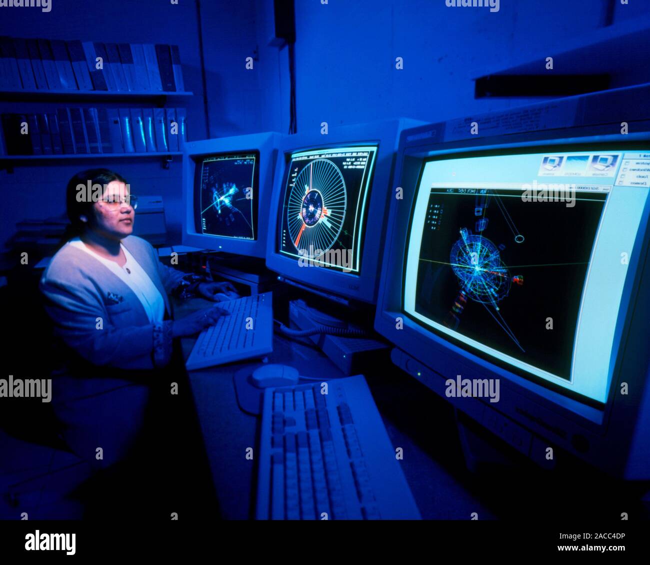 Particle physics. A woman physicist studies event displays from the D ...