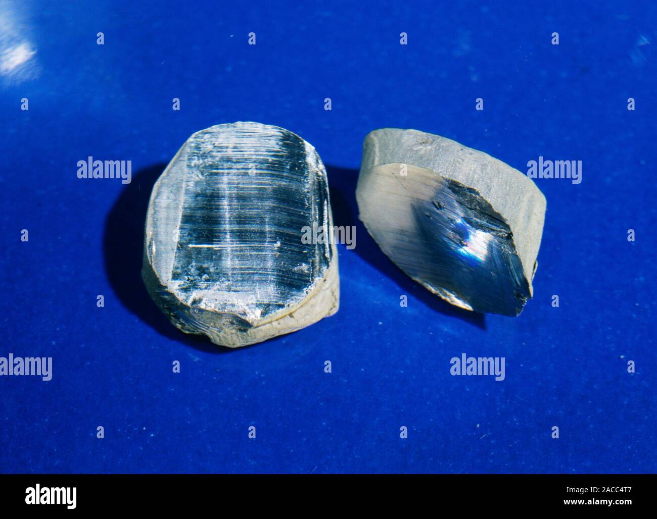 Sodium. Chunk of the reactive alkali metal sodium (Na), cut with a ...