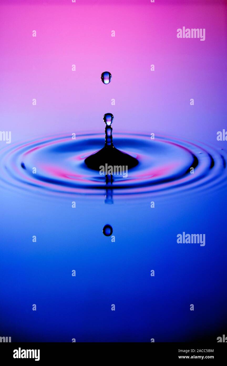 High speed flash of a water droplet hitting the surface of a liquid. A ...