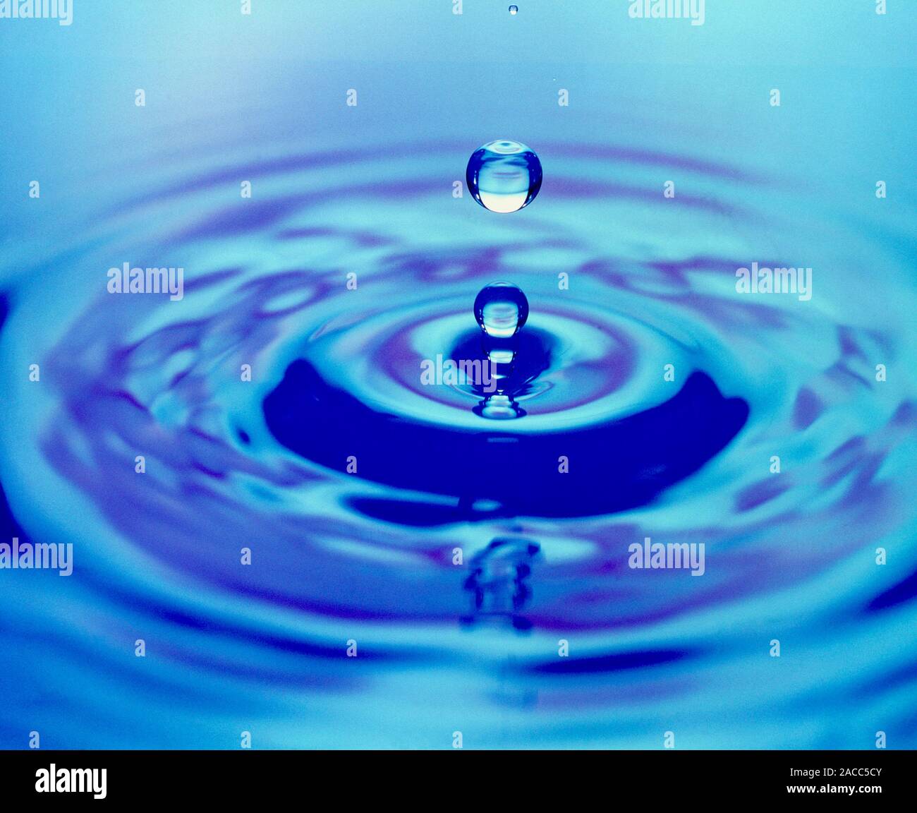 Water drop impact. High-speed photograph of a water drop impacting on a ...