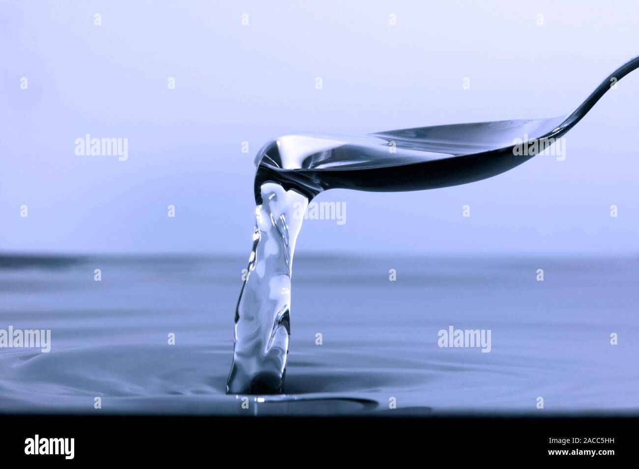 Water ripples. High-speed photograph of water falling from a spoon into ...