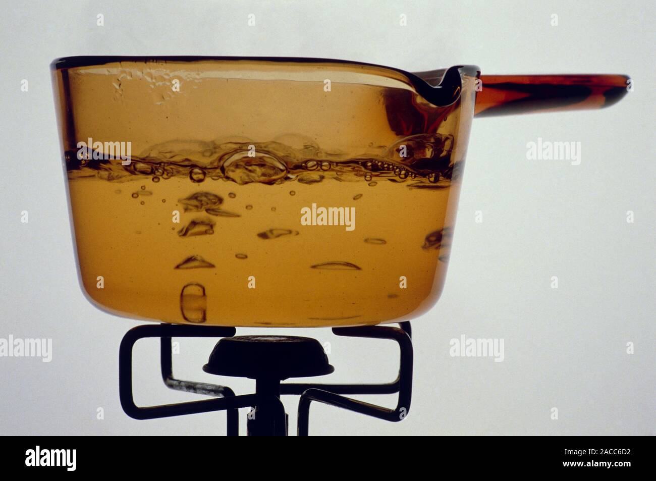 A pan of boiling water, showing air bubbles rising to the surface ...