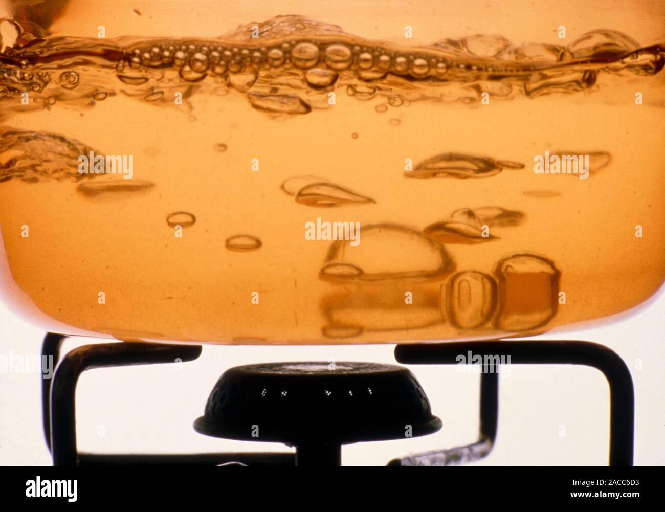 Close-up of the base of a pan of boiling water, showing air bubbles ...