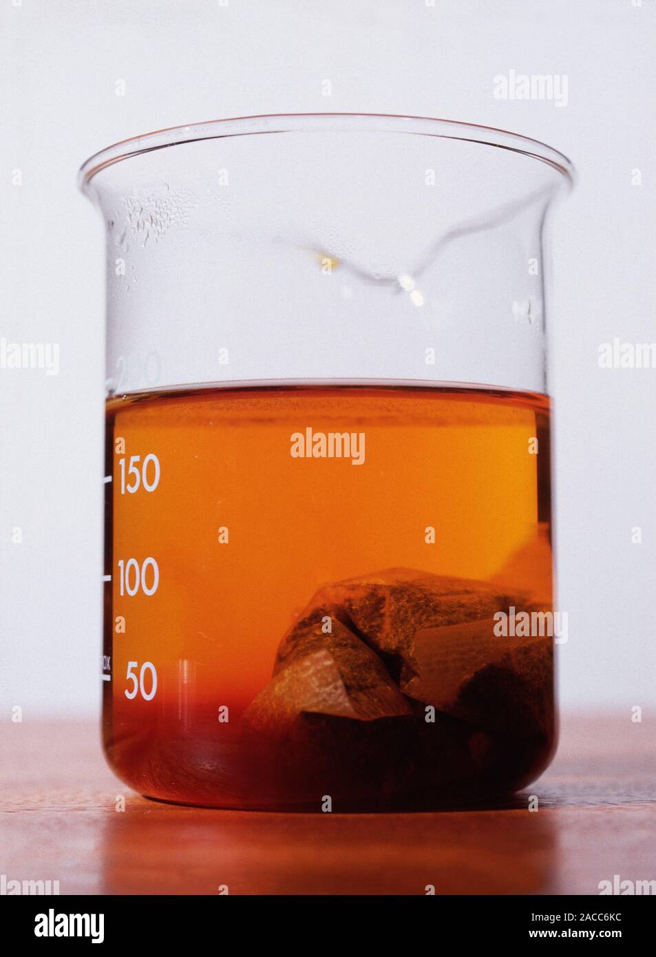 Diffusion. Tea dissolving in water in a beaker. Chemicals from the tea ...