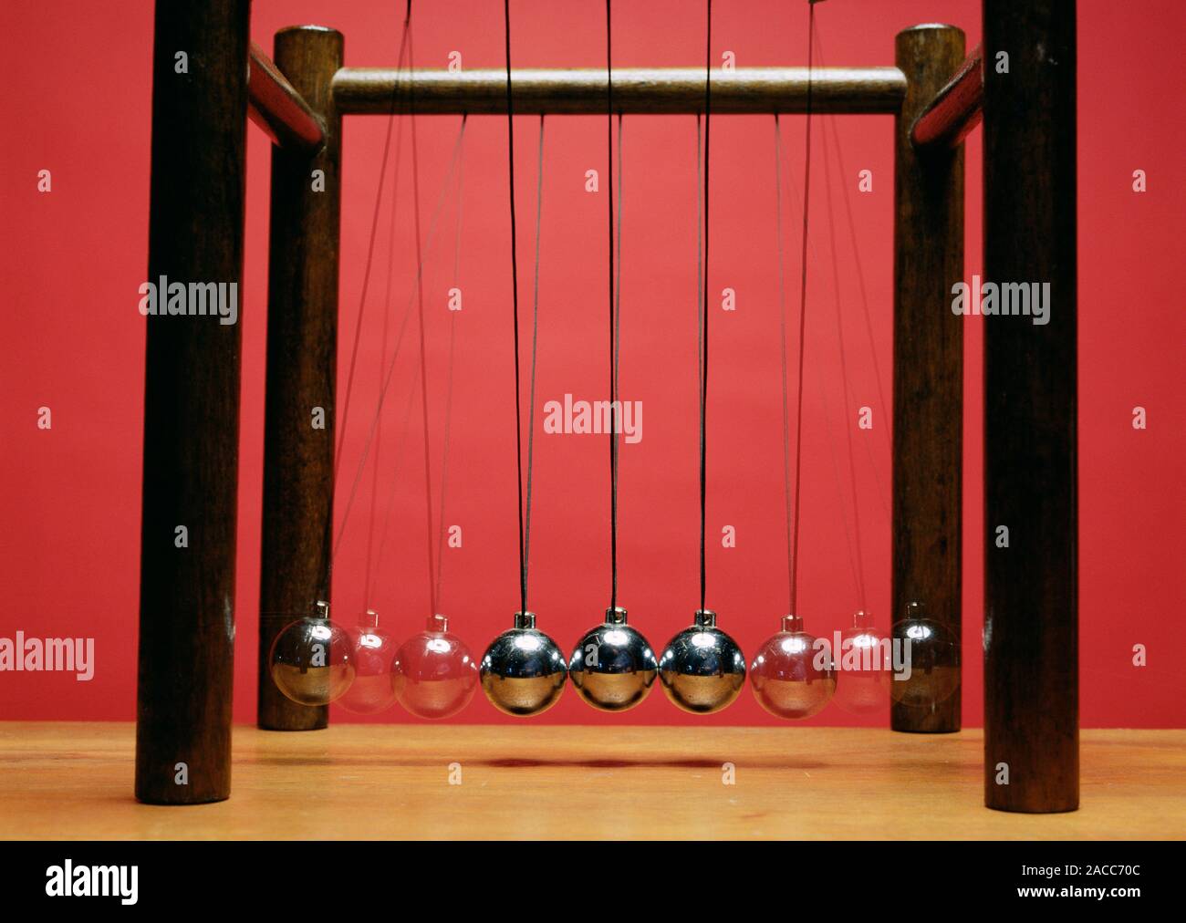 Newton's cradle in motion. This device consists of a set of balls ...