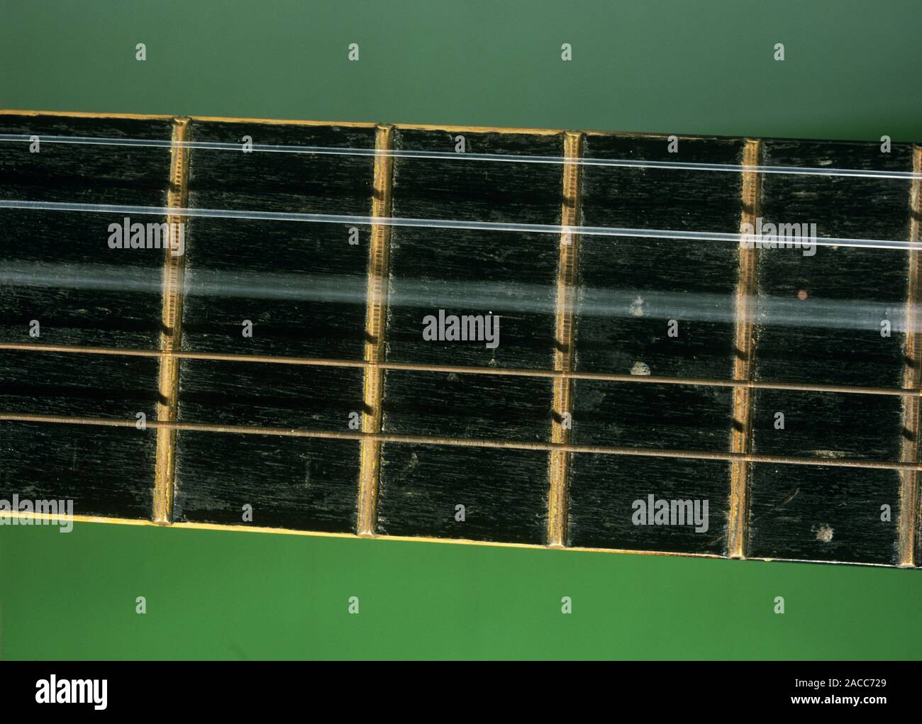 Guitar string vibrating. When plucked, the string vibrates at a ...