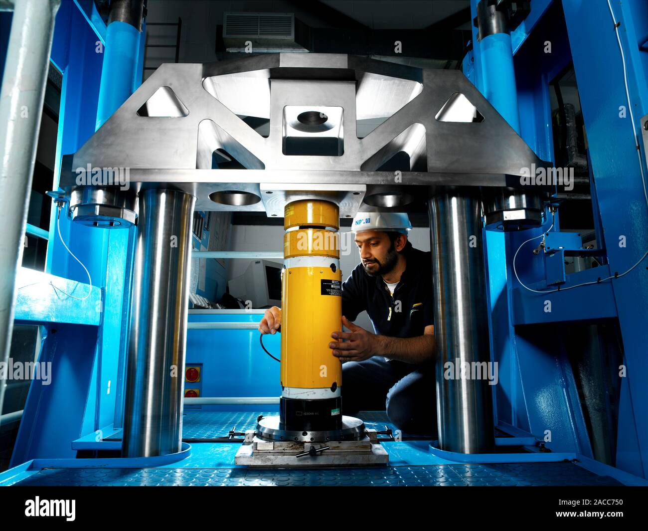 Deadweight force machine. Physicist setting up a load cell for ...