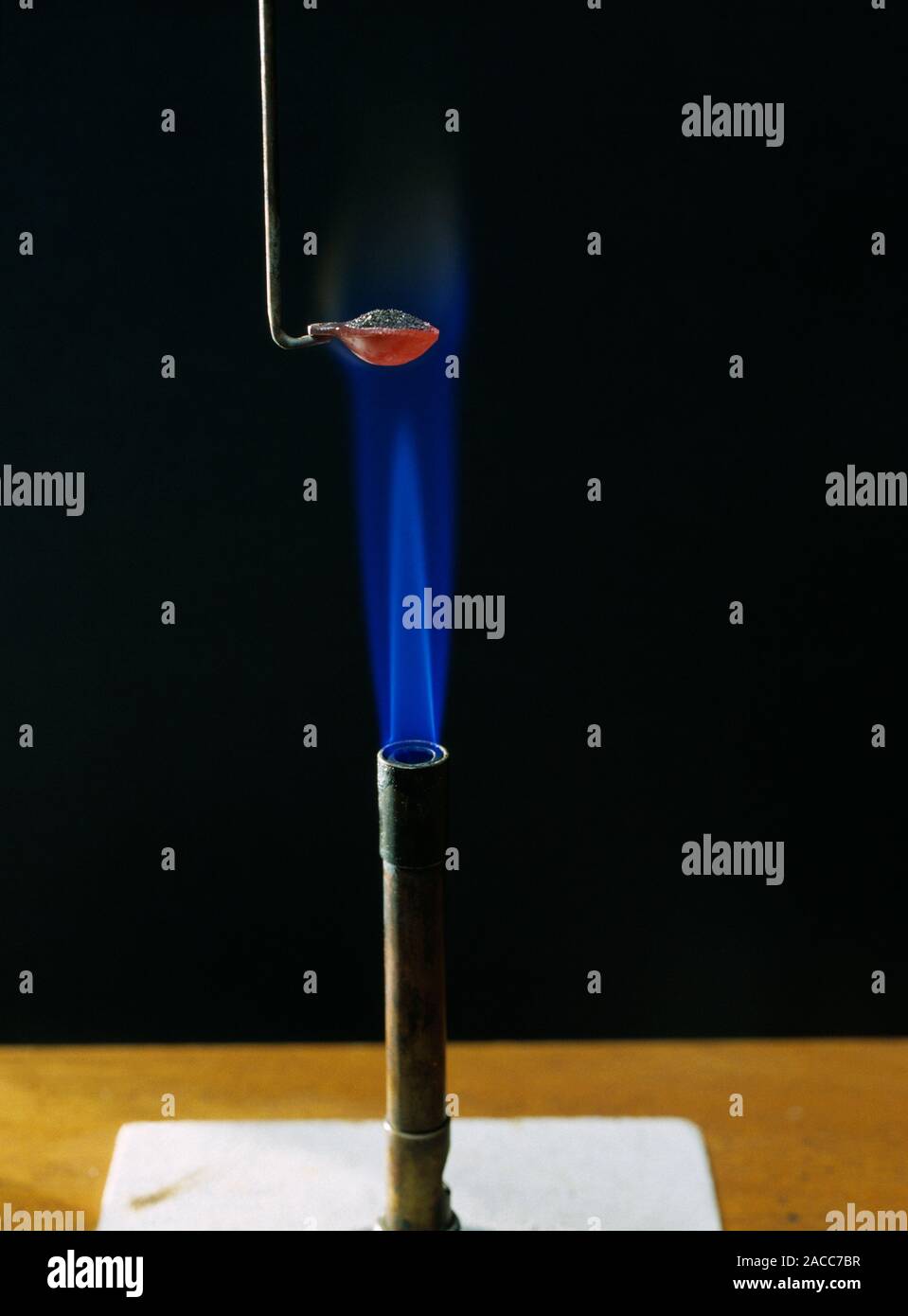 Iron filings being heated on a combustion spoon in the flame of a ...