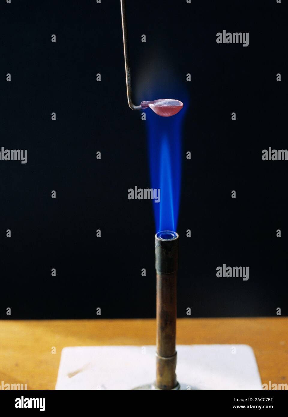 Copper powder being heated on a combustion spoon in the flame of a ...