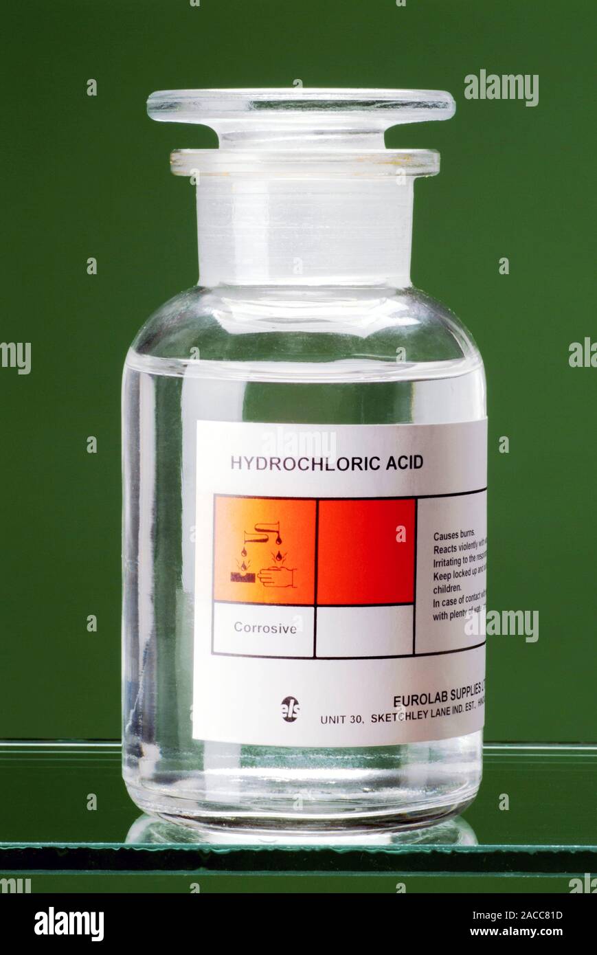 Bottle of hydrochloric acid. The hazard label warns that this strong ...