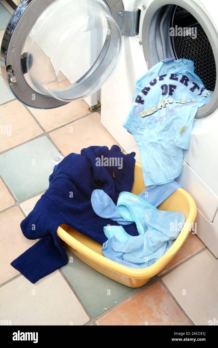 Colour running during washing. Clothes in a washing machine showing ...