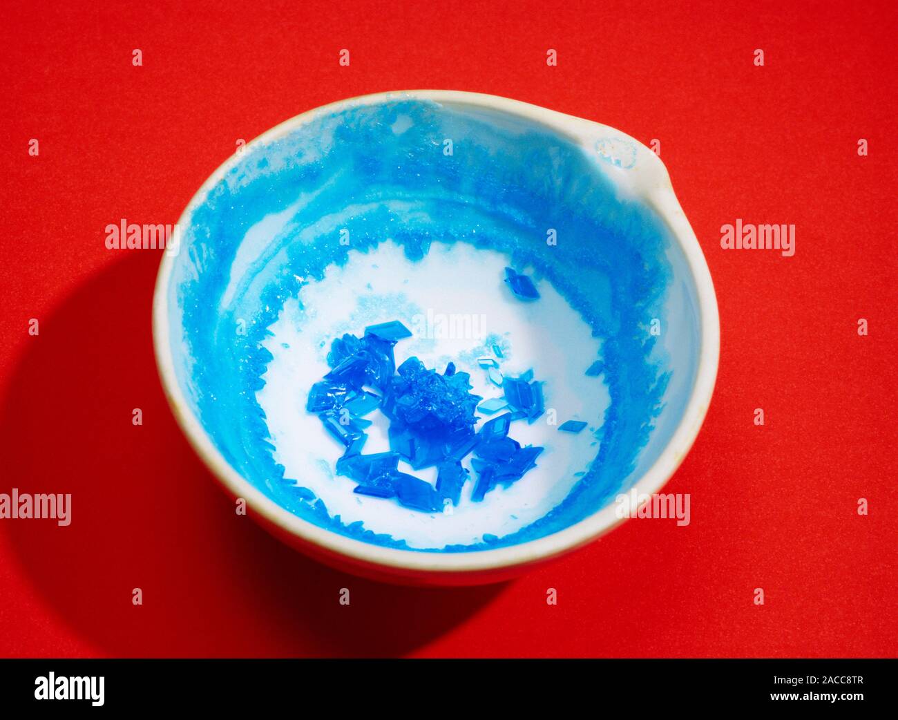 Copper sulphate (CuSO4) crystals in a crystallising dish. The crystals ...