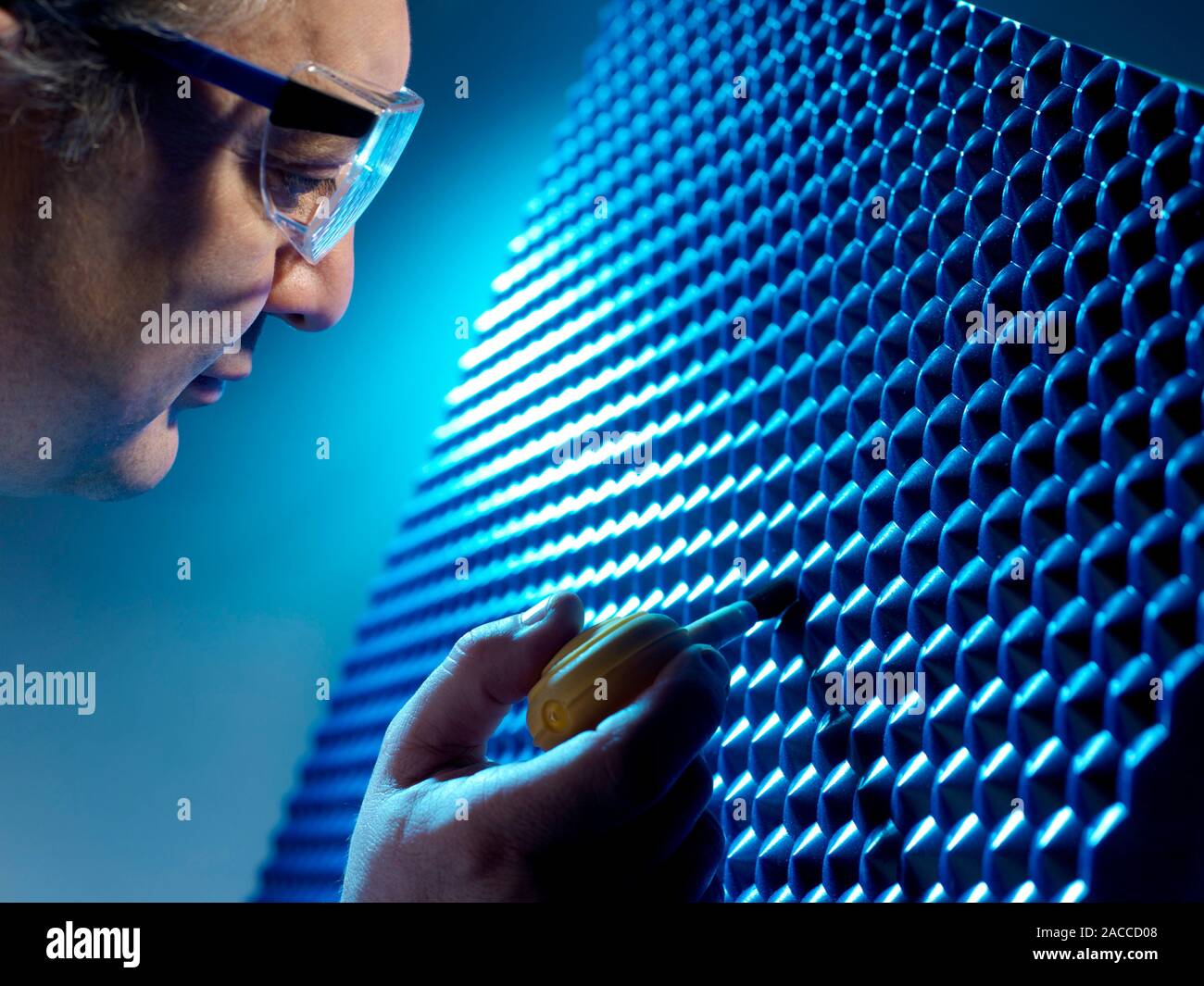 Anechoic tile. Technician cleaning an anechoic polyurethane tile that ...
