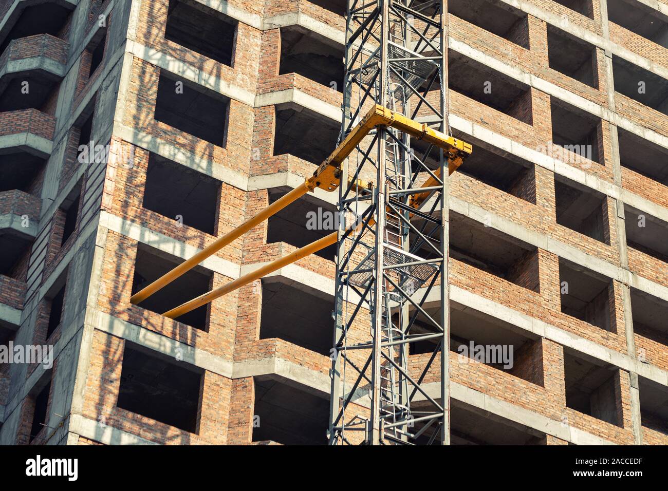 Close-up detail of highrise tower crane attached to building brick wall ...