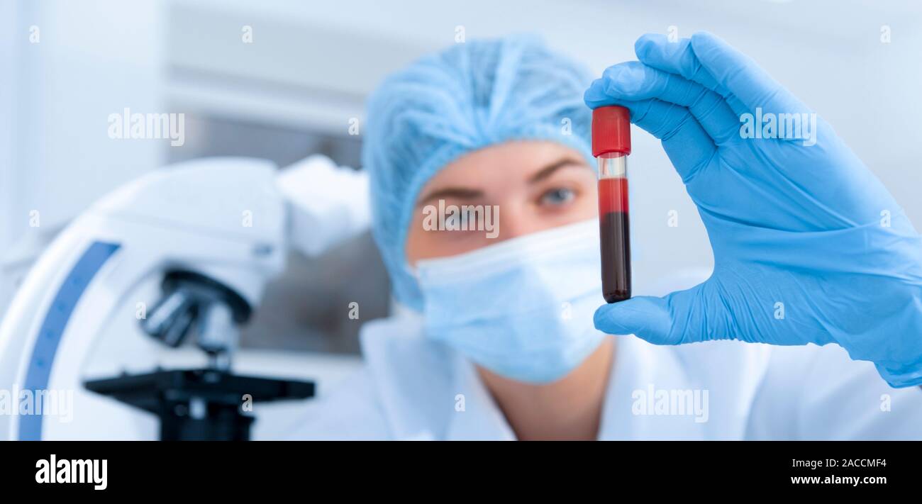 Female scientist making researches with blood in clinical laboratory ...