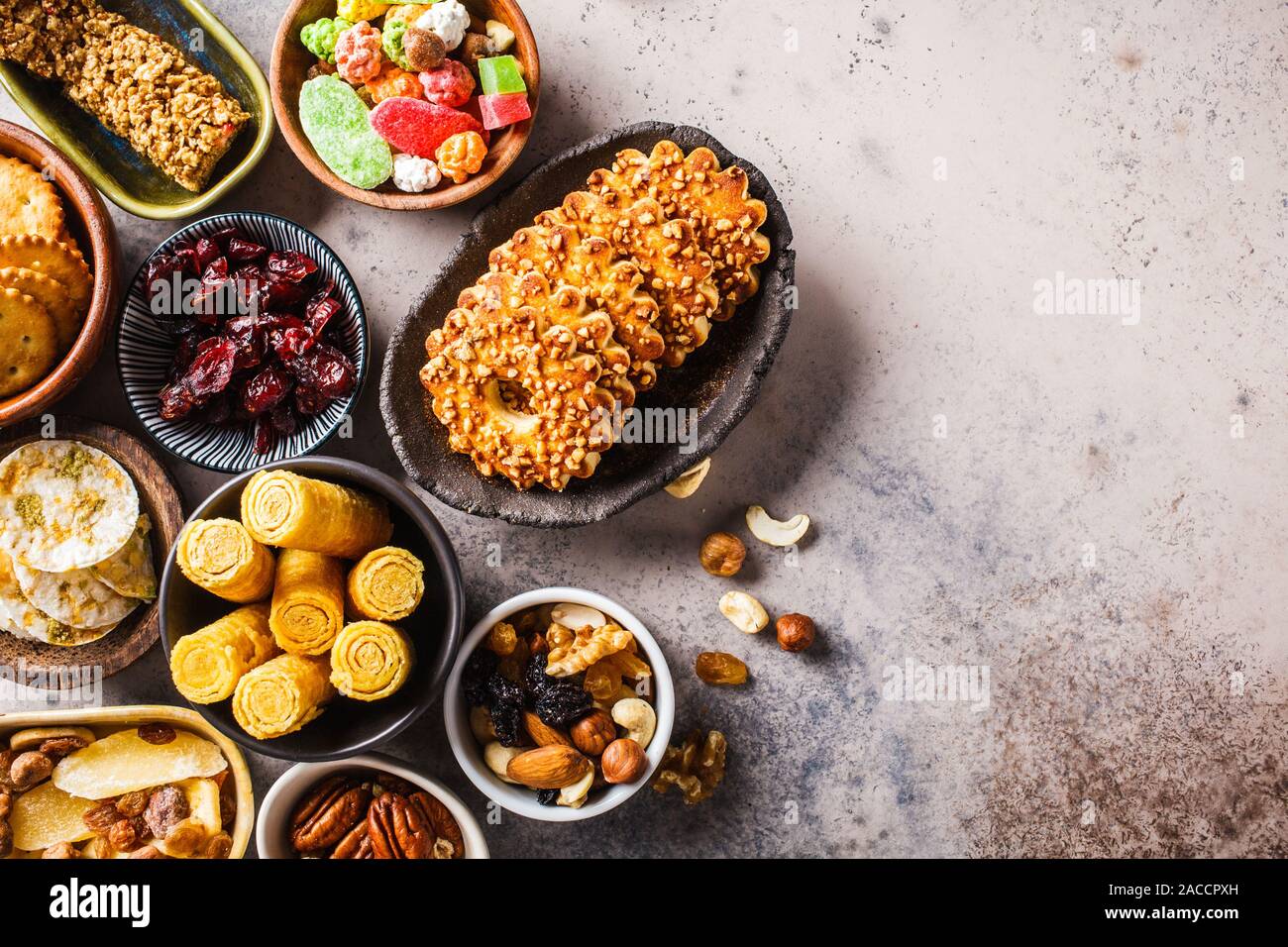 Variety of snacks and sweets on a gray background. Waffles, nuts ...