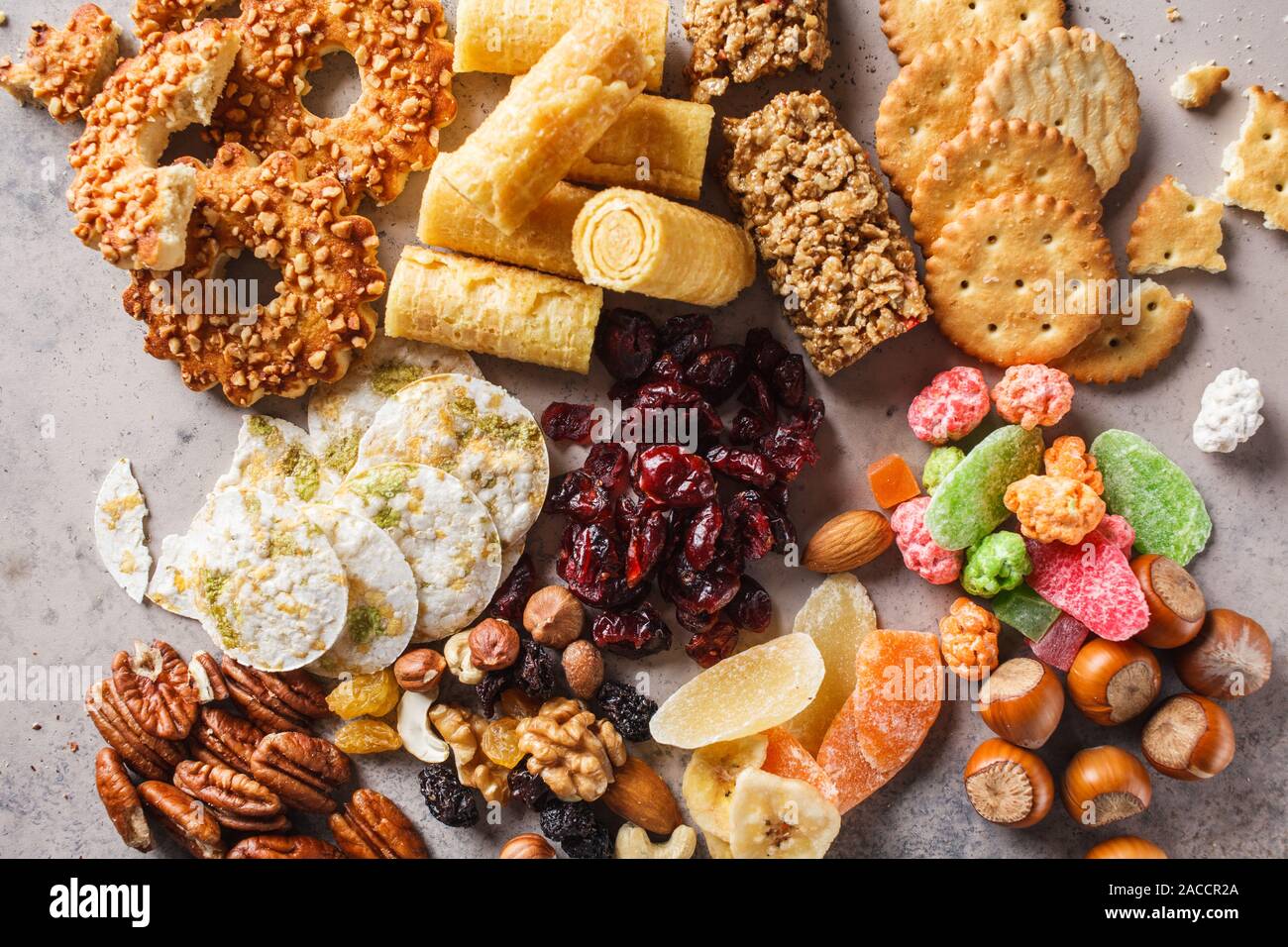 Variety of snacks and sweets on a gray background. Waffles, nuts ...