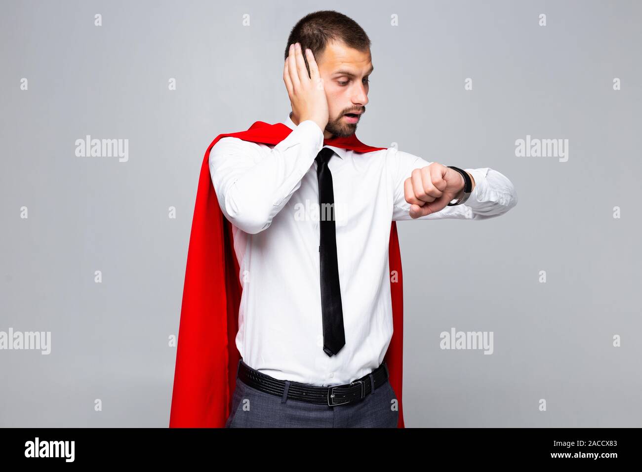 Young business man super hero look at watch isolated on white ...