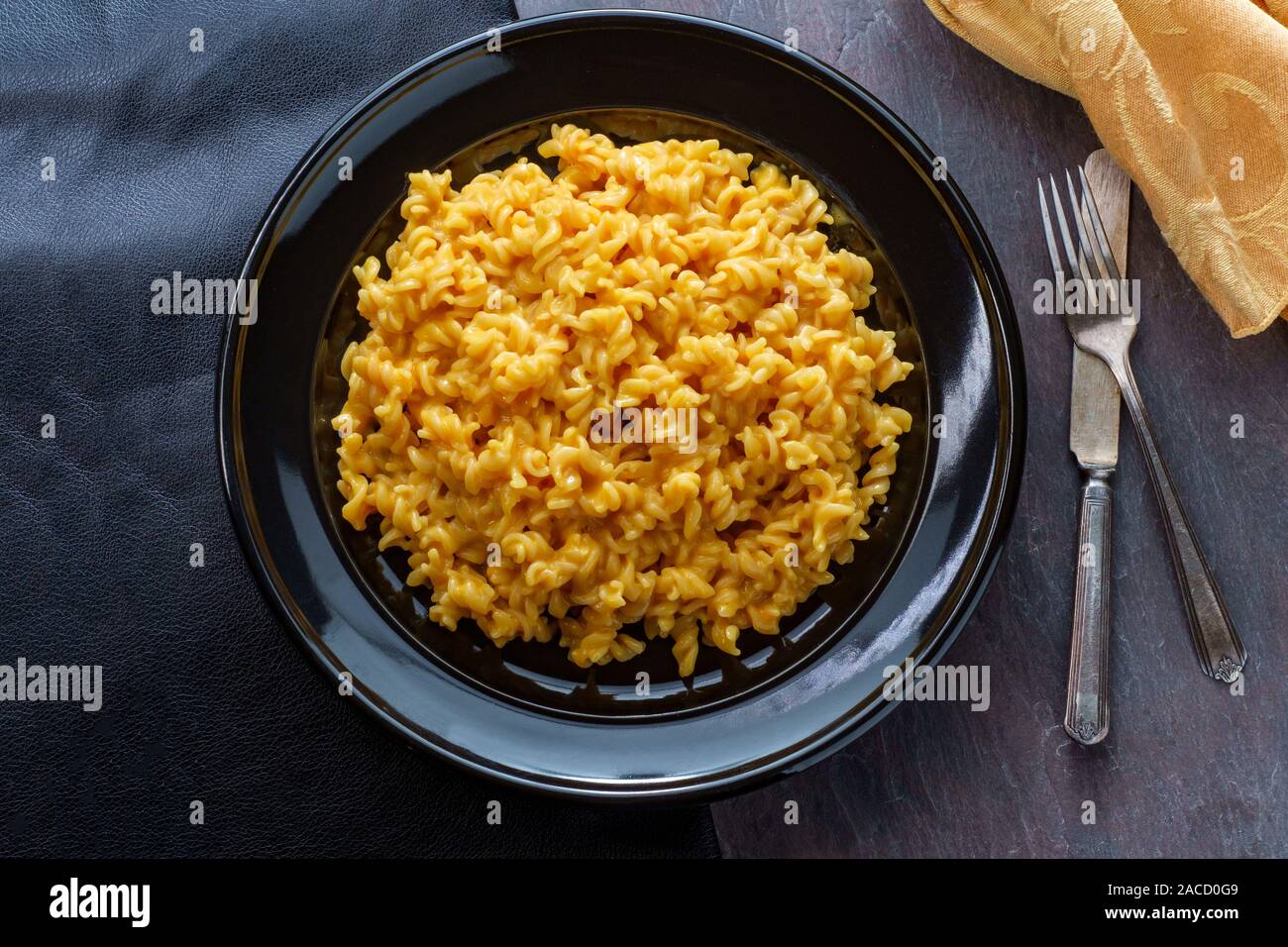 Delicious spiral macaroni and cheddar cheese on black plate Stock Photo ...