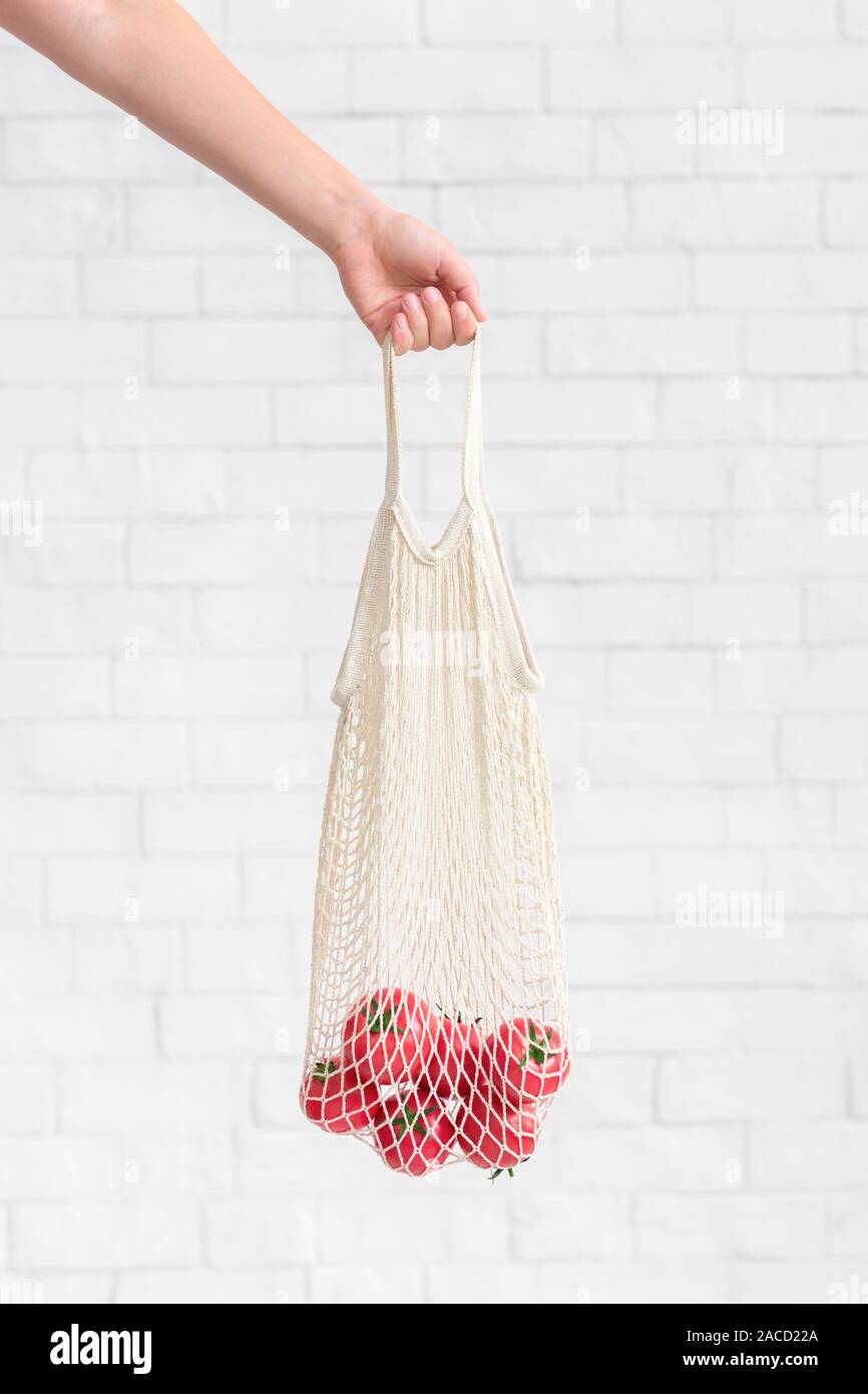 Woman carrying Clean and eco tomatoes in reusable net bag Stock Photo ...