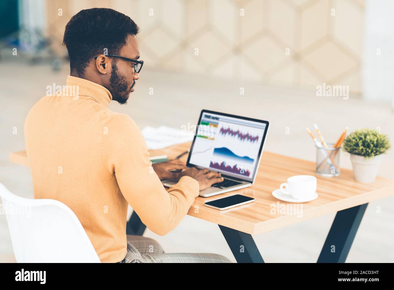 Black manager working with diagrams on pc Stock Photo - Alamy