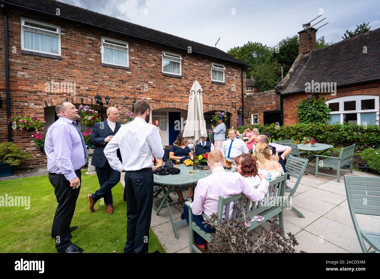Bride, Groom and wedding guests pose for picture outside at the Manor ...