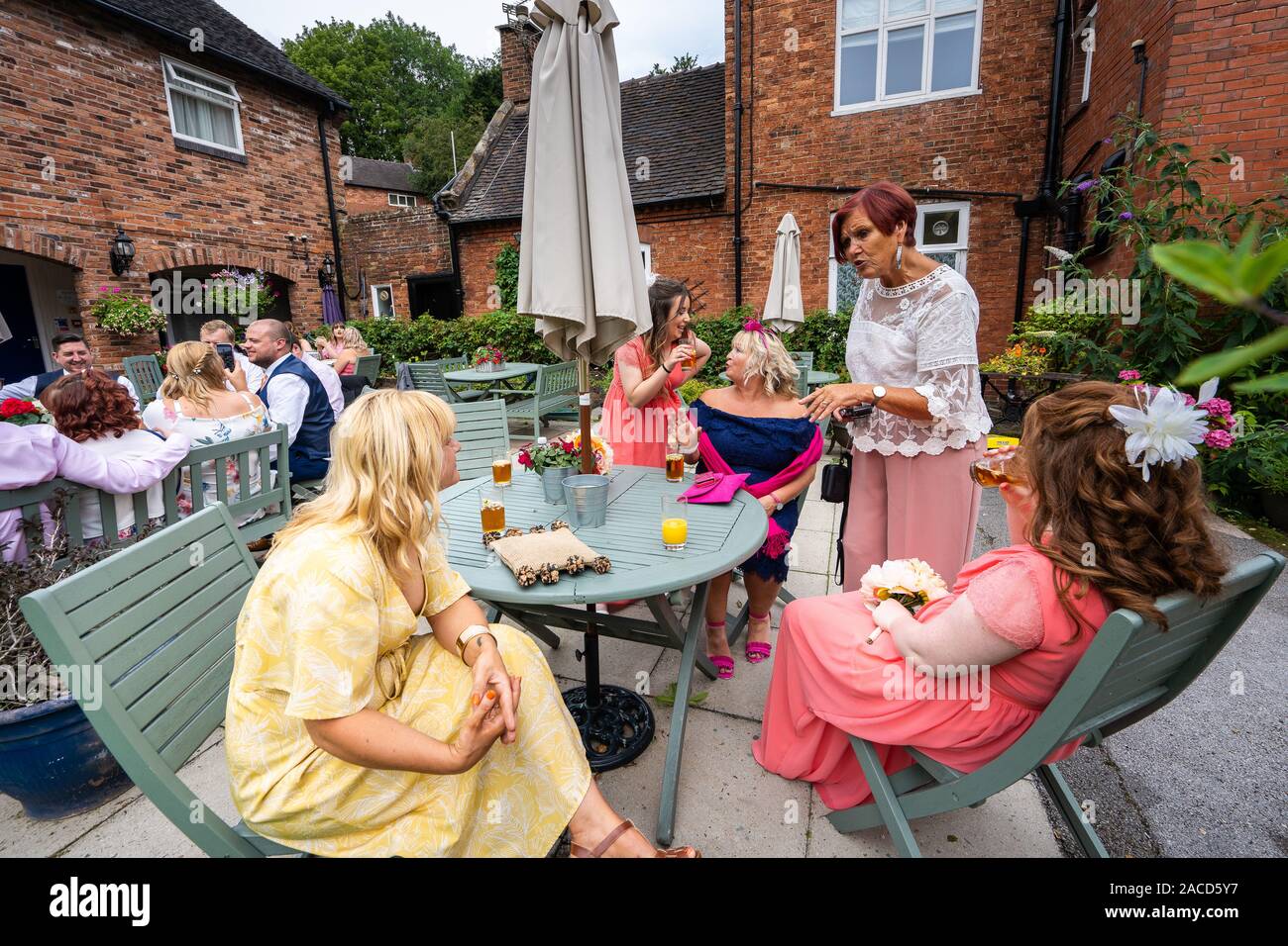 Bride, Groom and wedding guests pose for picture outside at the Manor ...