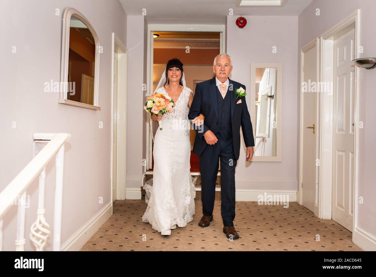 A proud father walks his daughter down the isle ready for a traditional ...