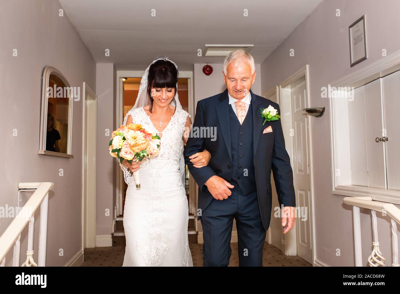 A proud father walks his daughter down the isle ready for a traditional ...