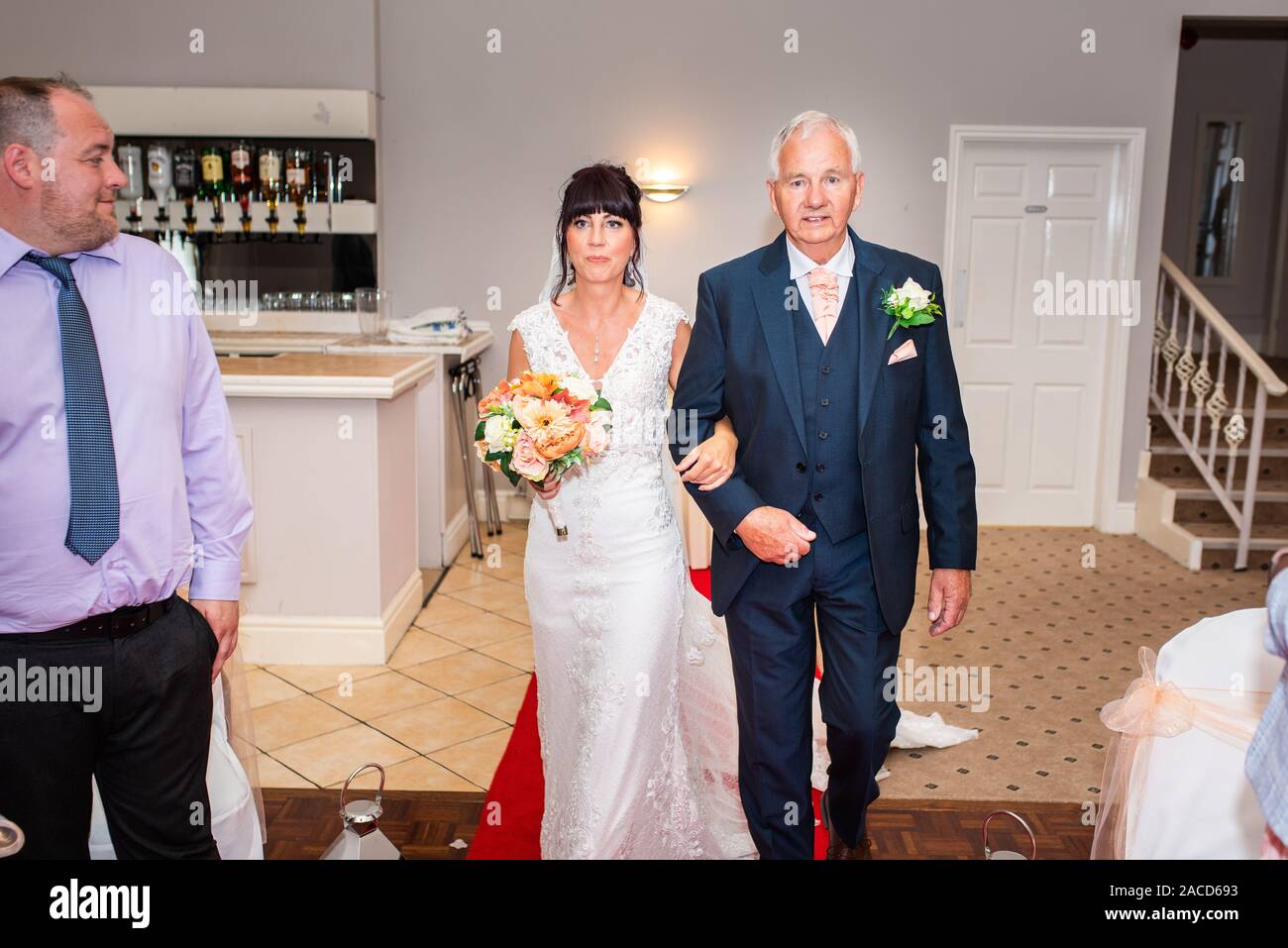 A proud father walks his daughter down the isle ready for a traditional ...