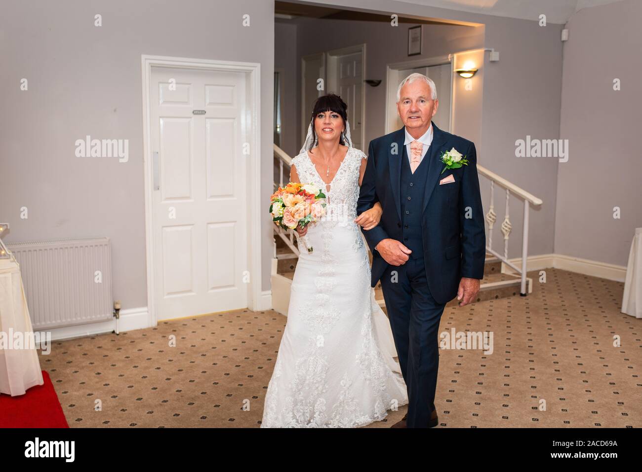 A proud father walks his daughter down the isle ready for a traditional ...