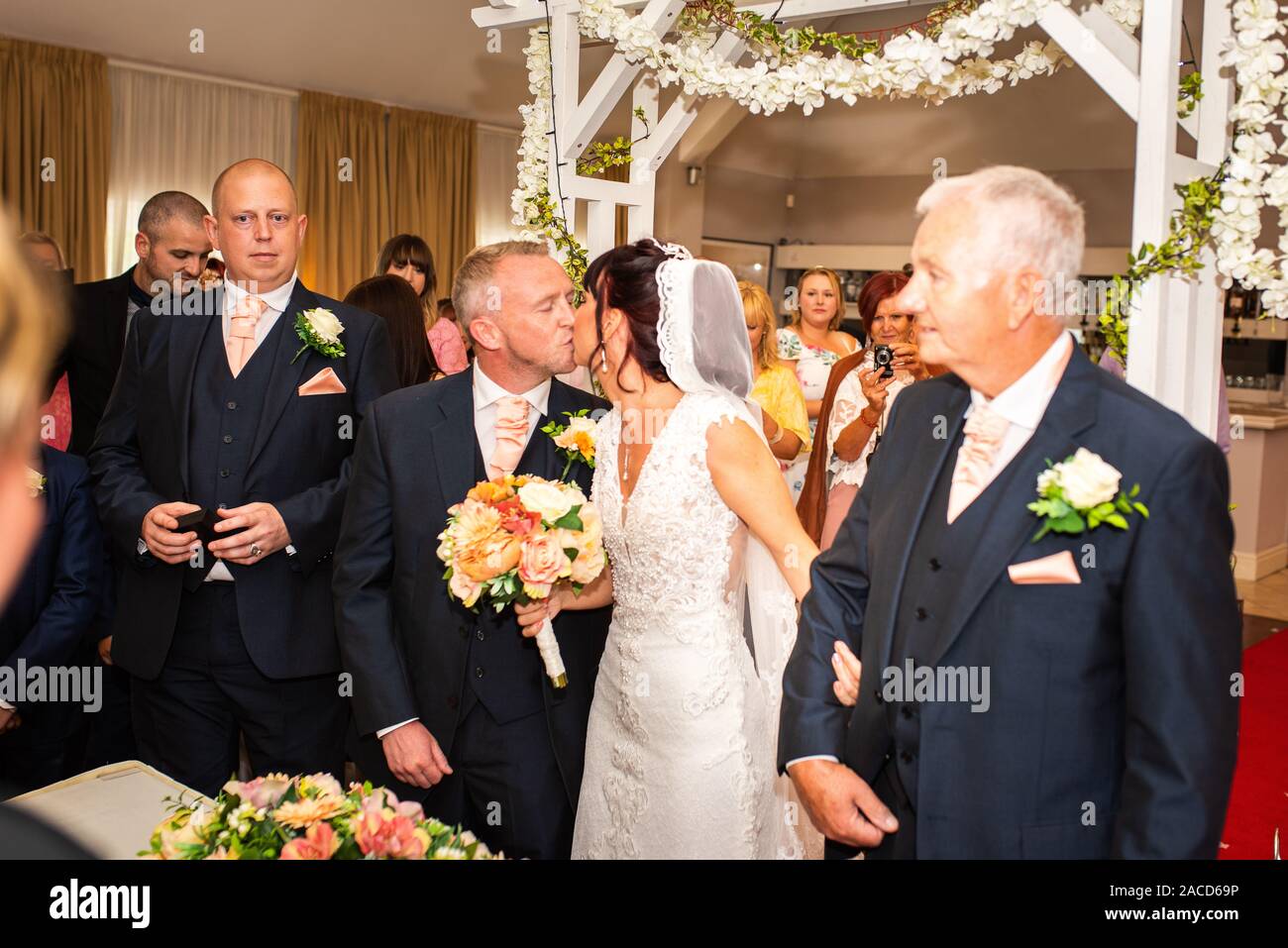 A proud father walks his daughter down the isle ready for a traditional ...