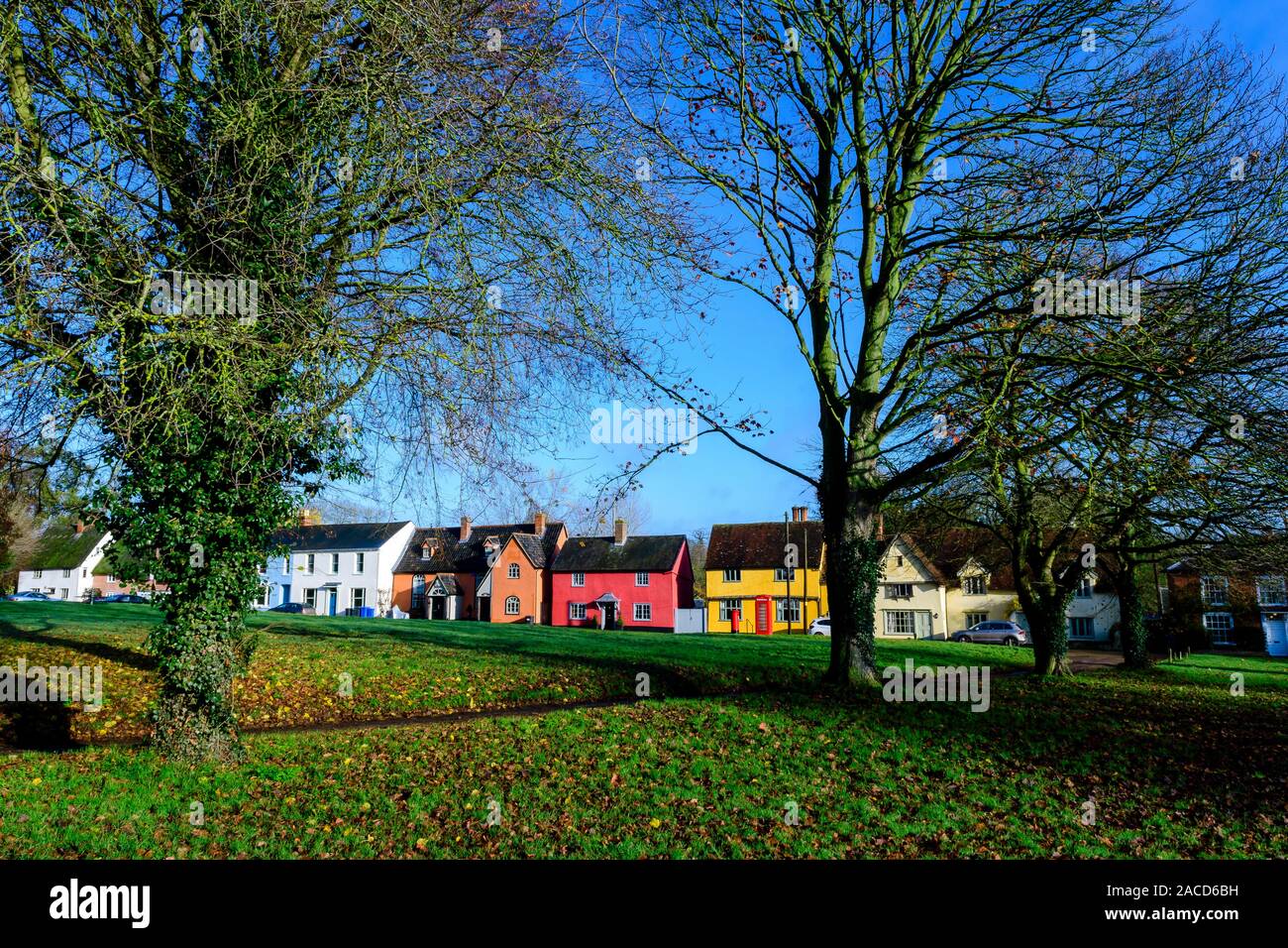 Colourful cottages framed by trees on the village green in the Suffolk ...