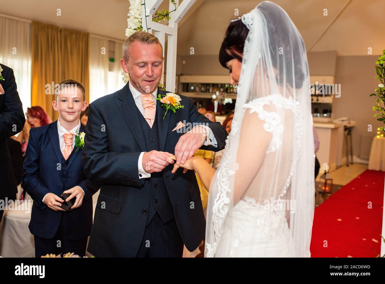 A couple get married indoors in a traditional English wedding ceremony ...