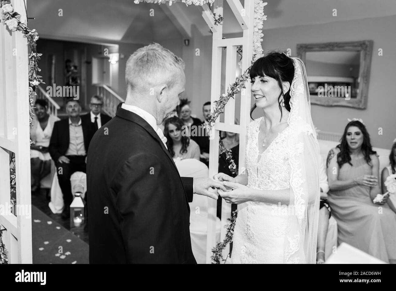 A couple get married indoors in a traditional English wedding ceremony ...